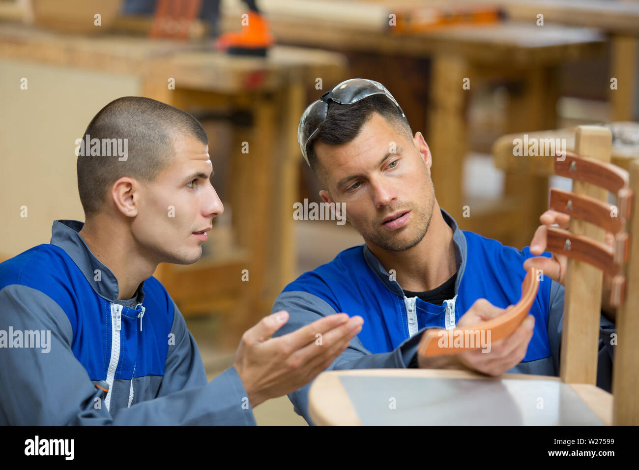 apprentice carpenter working on chair with foreman Stock Photo - Alamy