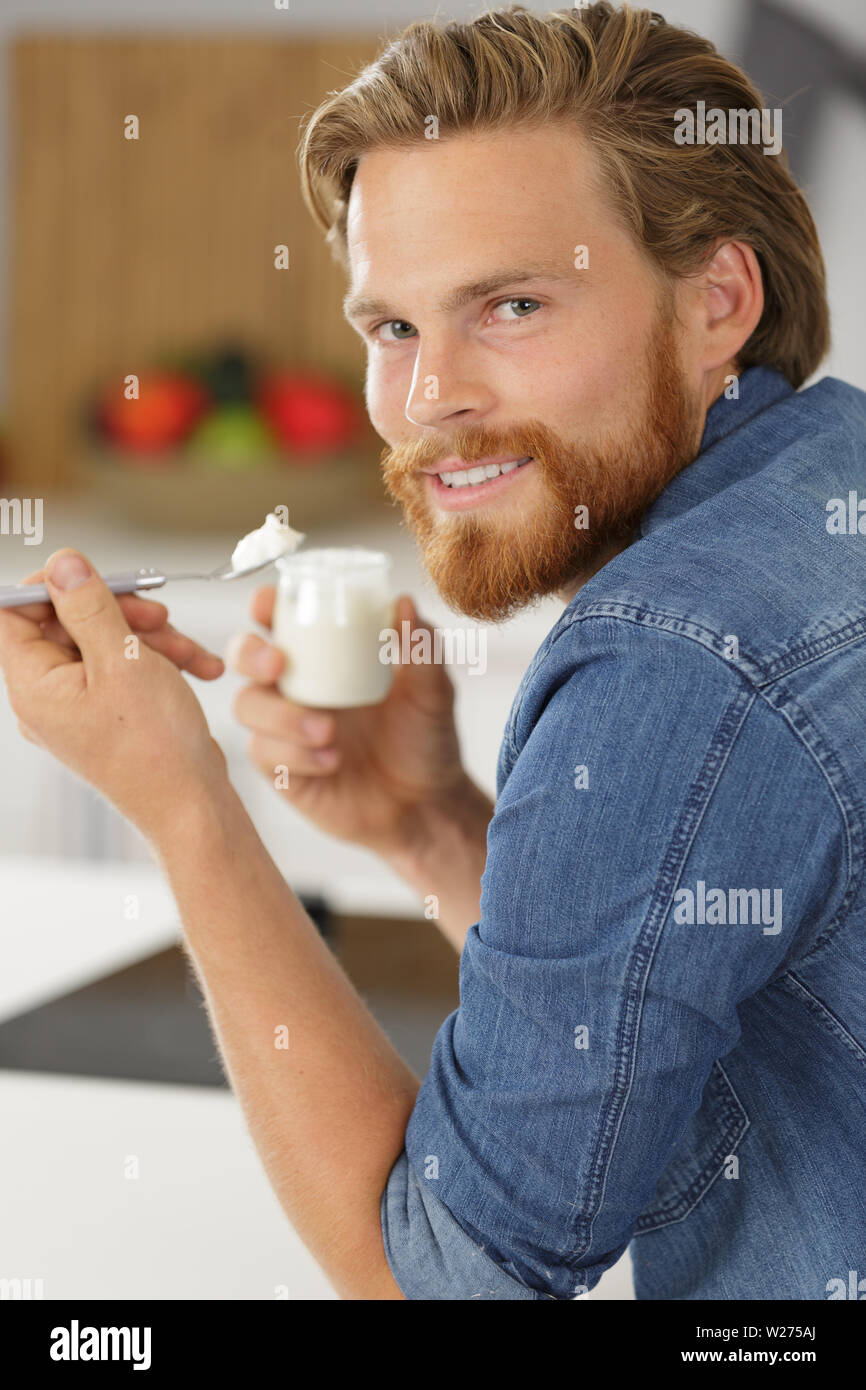 happy man eating yogurt at home Stock Photo - Alamy