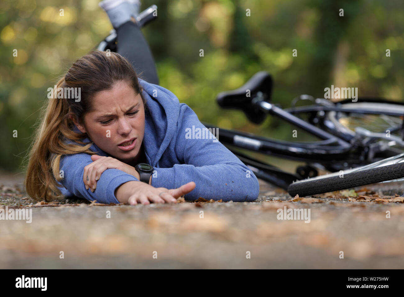 woman cyclist with injuries after falling down from bicycle Stock Photo ...