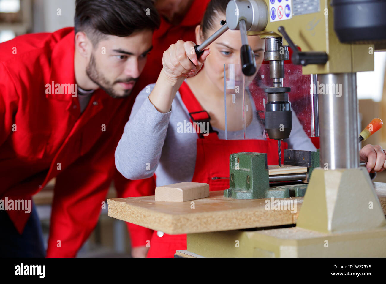 female worker using bench drill under supervision Stock Photo - Alamy