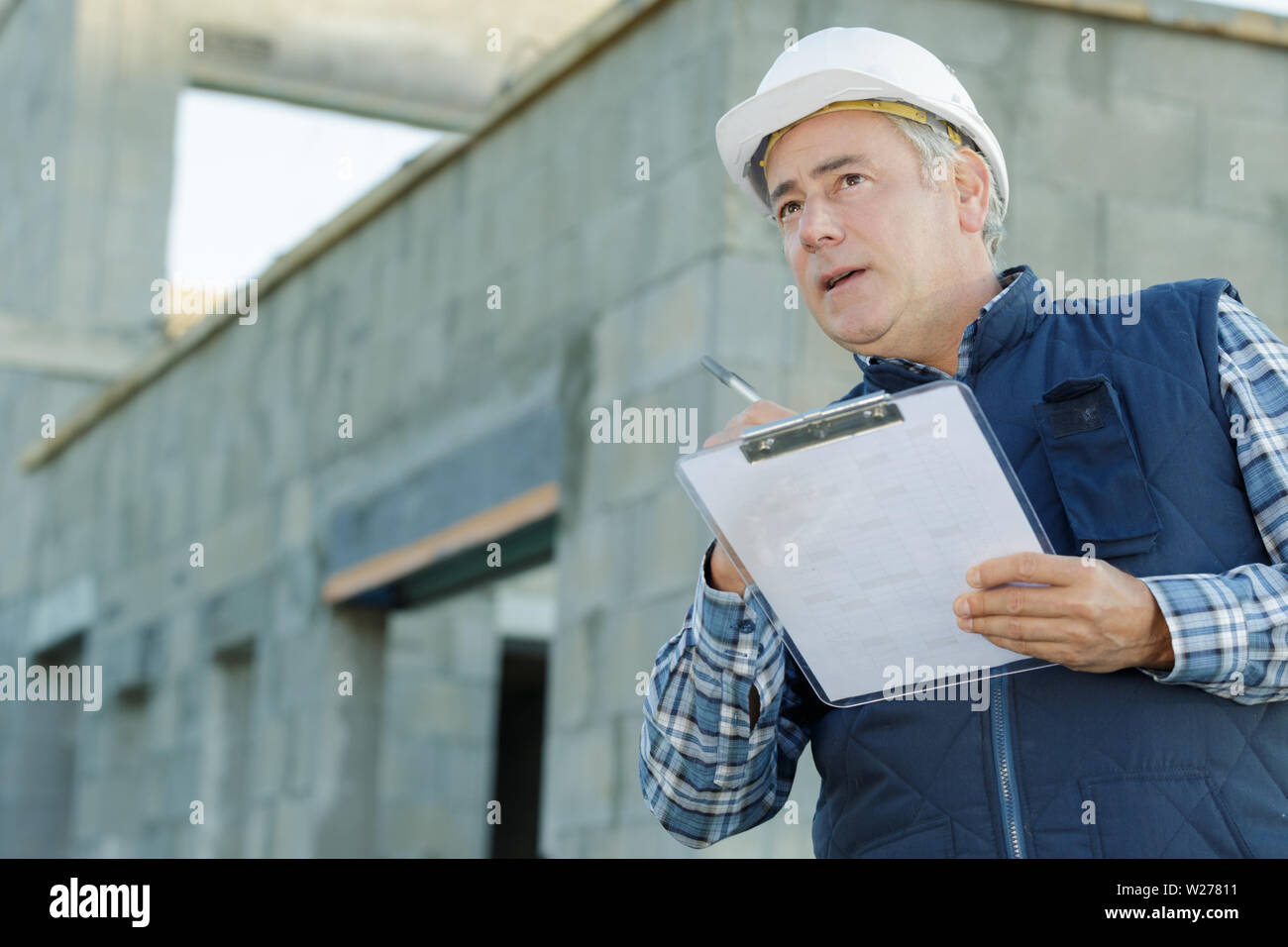 portrait of workman preparing estimate for work on house Stock Photo ...