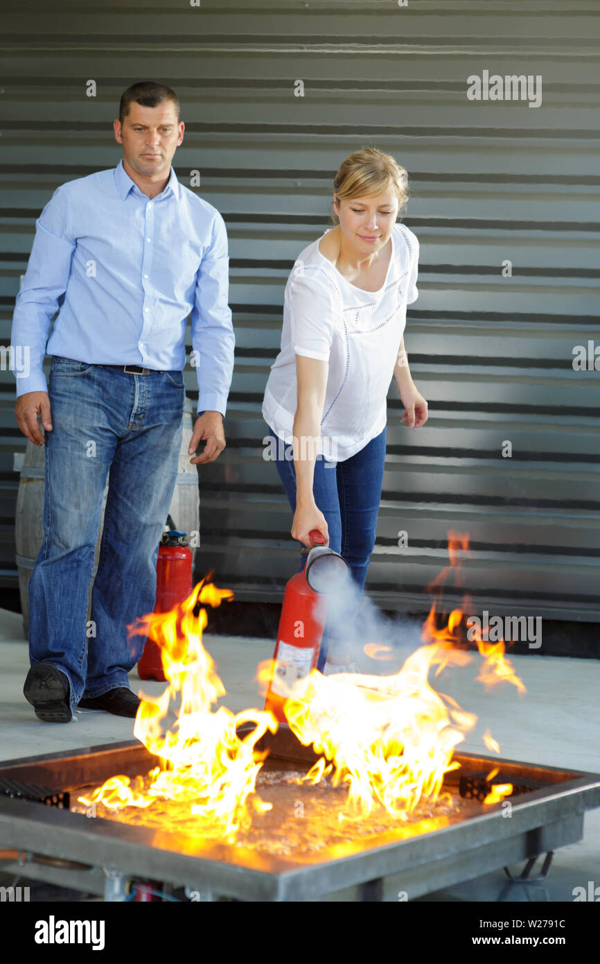 closeup woman operating a fire extinguisher Stock Photo - Alamy