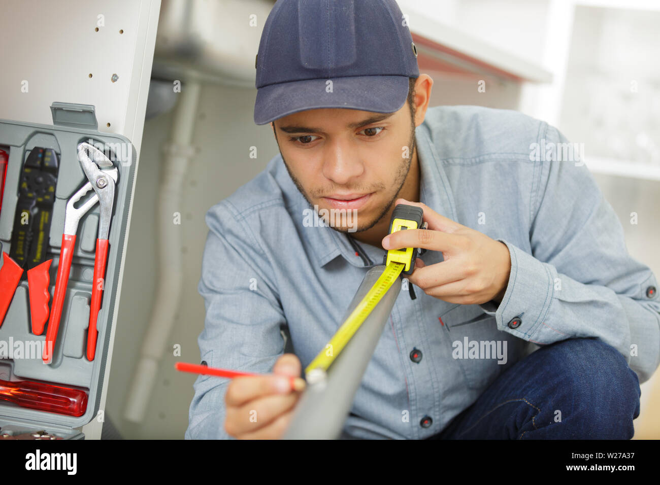 a man measuring a piece of wood Stock Photo - Alamy