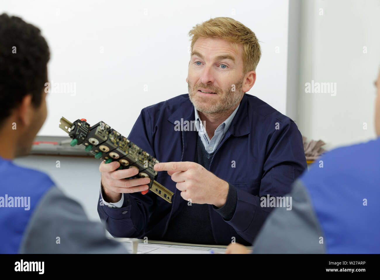 teacher showing component to electronics students Stock Photo - Alamy