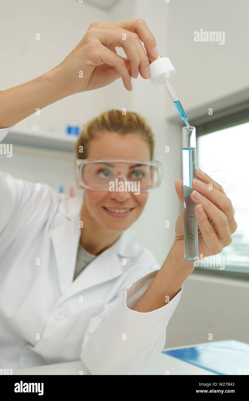 female scientist holding pipette in lab wearing safety goggles Stock ...