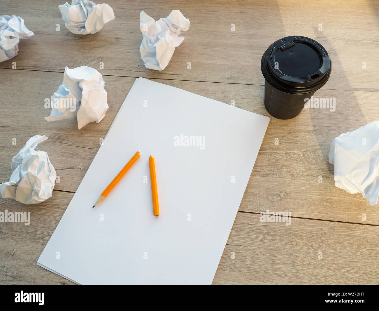 Writing concept - crumpled up paper wads with a sheet of white paper ...