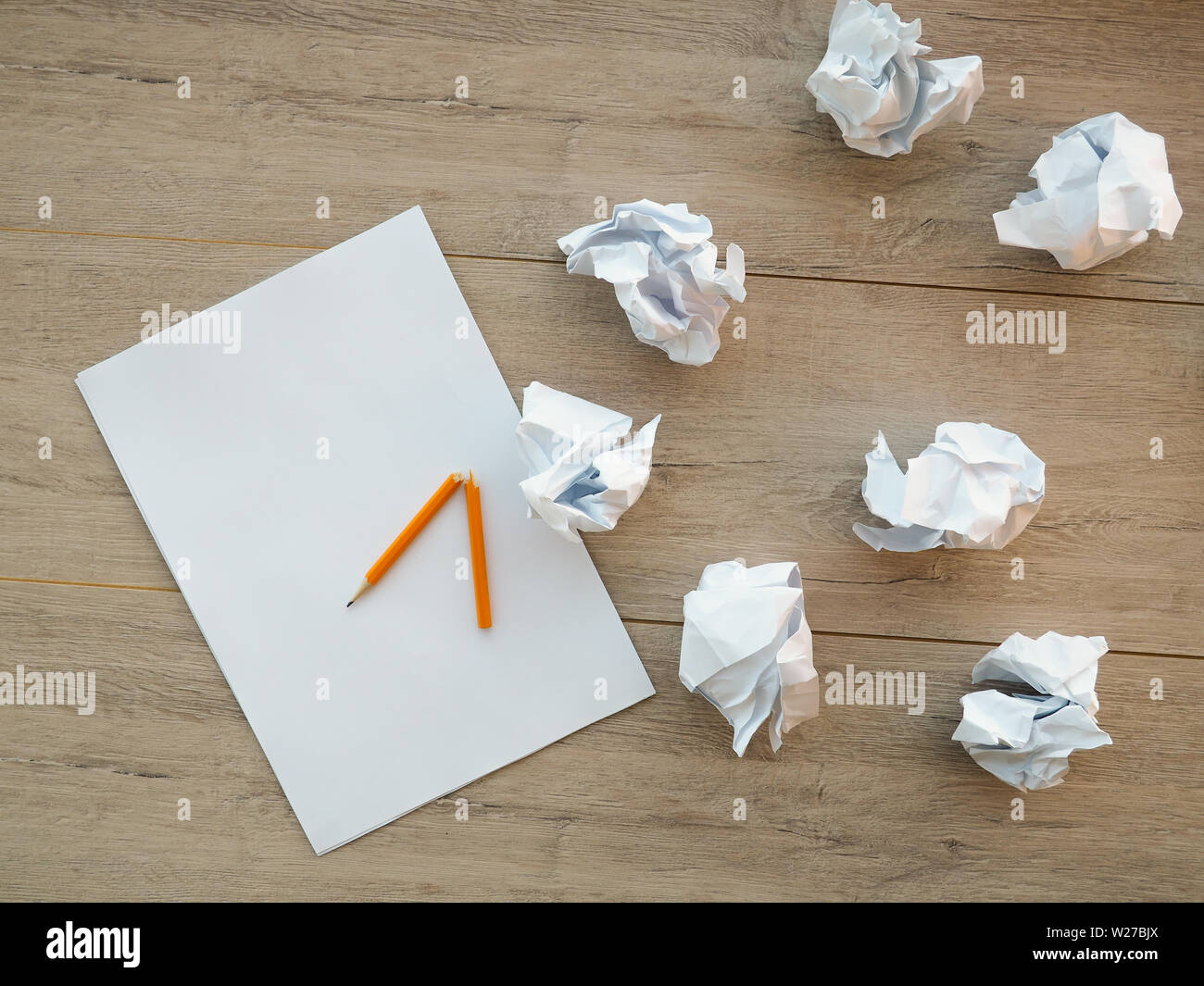 Writing concept - crumpled up paper wads with a sheet of white paper ...