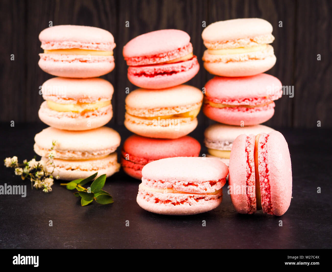Colorful French or Italian macarons stack on dark wood table with copy ...
