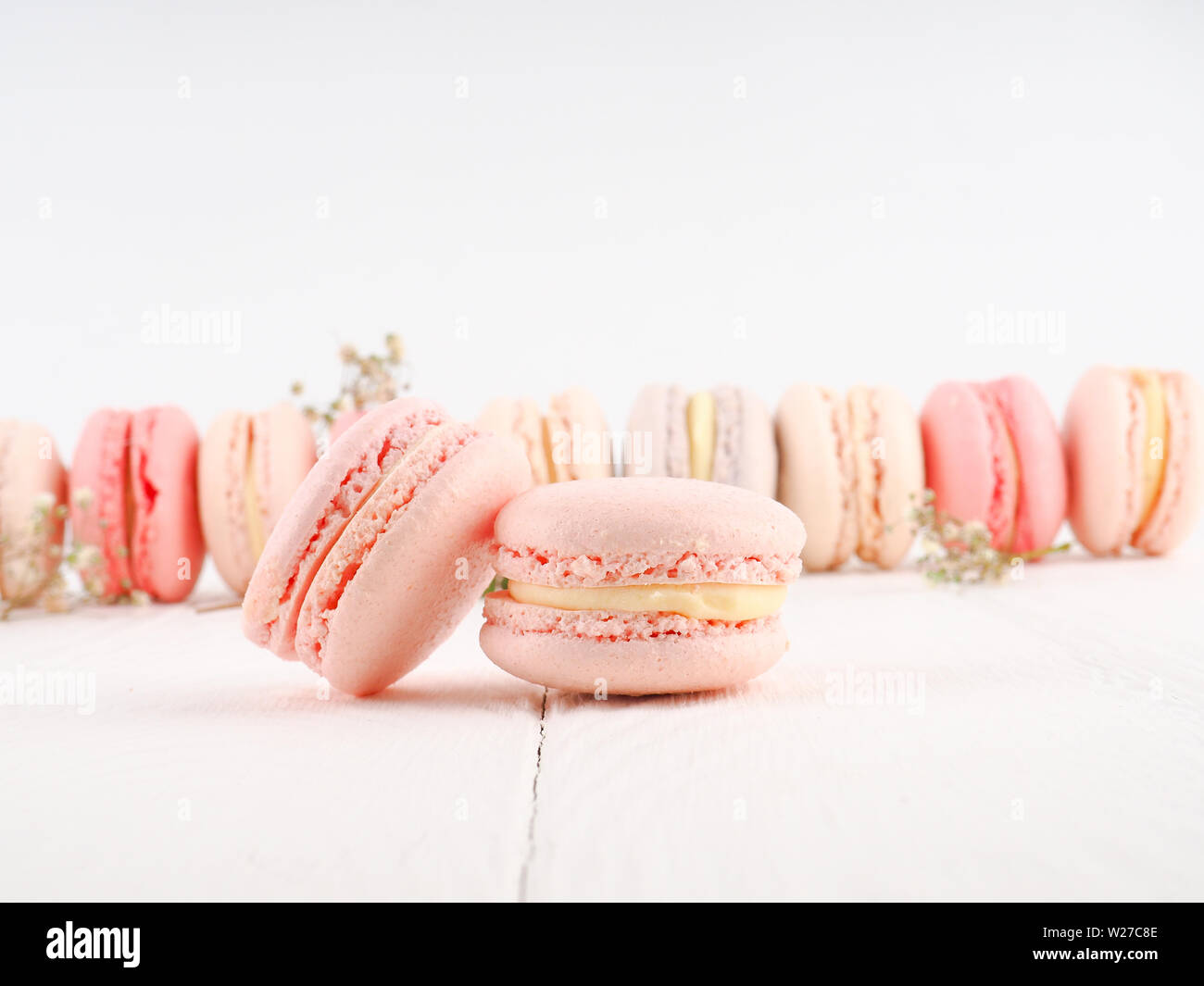 Colorful French or Italian macarons stack on white wood table with copy ...