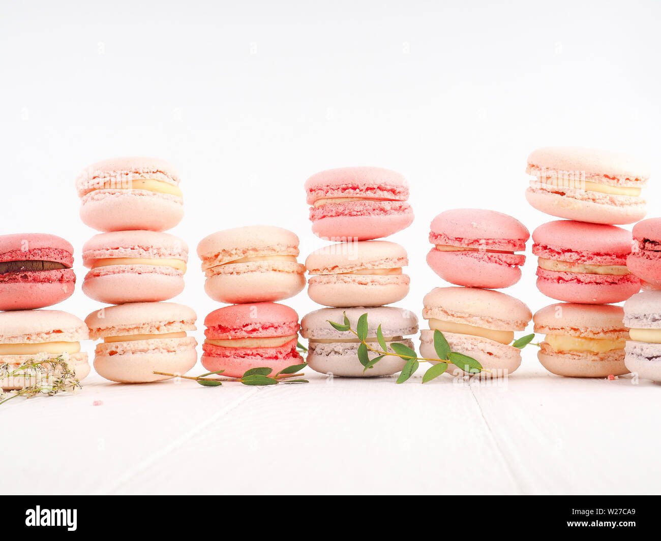 Colorful French or Italian macarons stack on white wood table with copy ...
