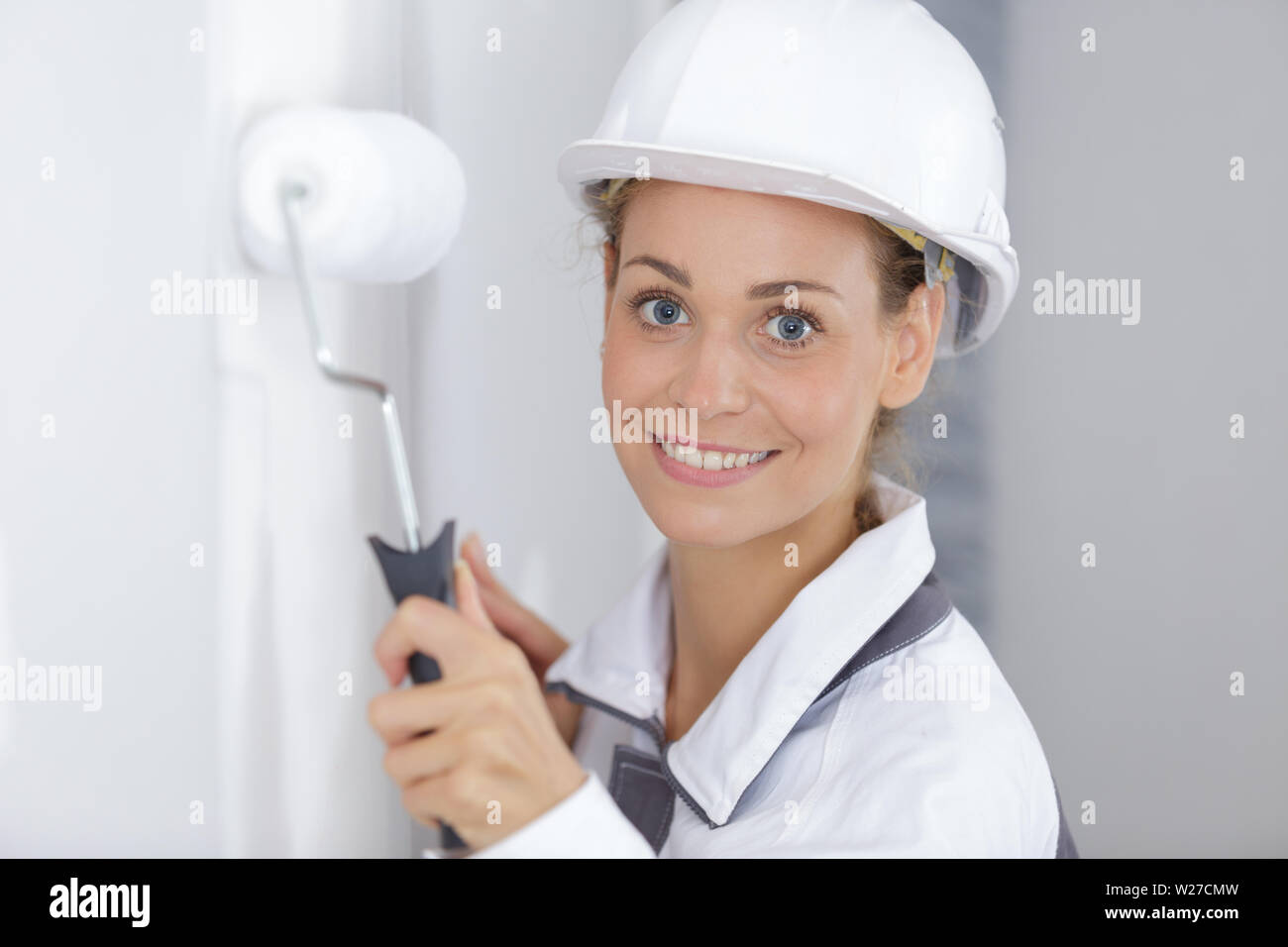 happy female builder painting the wall Stock Photo - Alamy