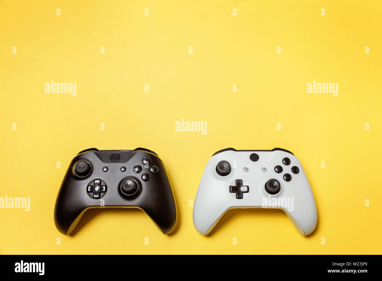 White and black two joystick gamepad, game console on yellow colourful ...