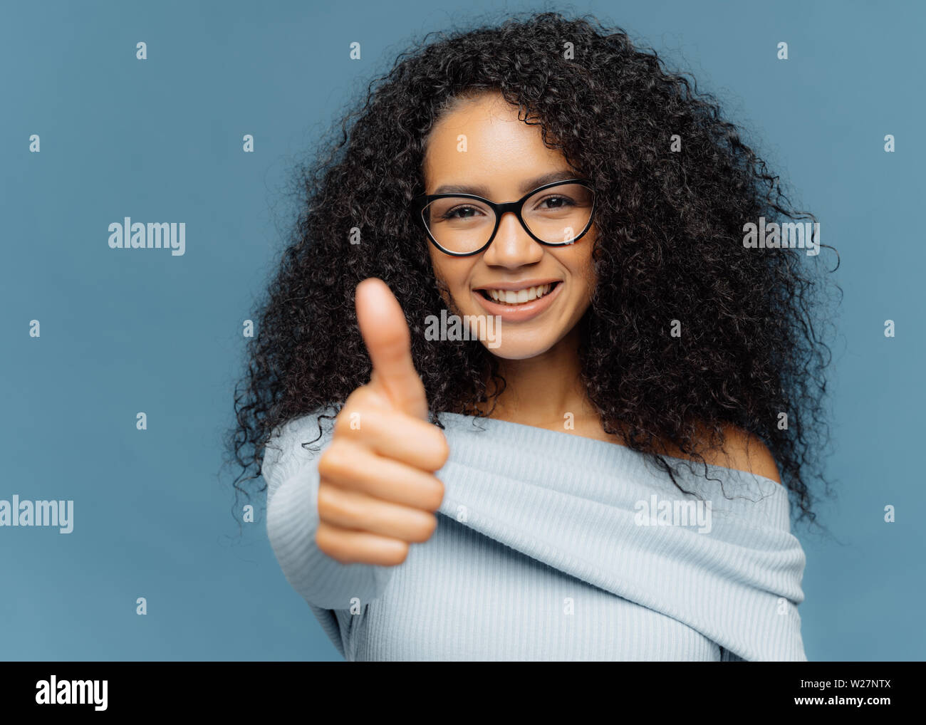 Portrait Of Dark Skinned Female Has Thumb Up Shows Agreement Or