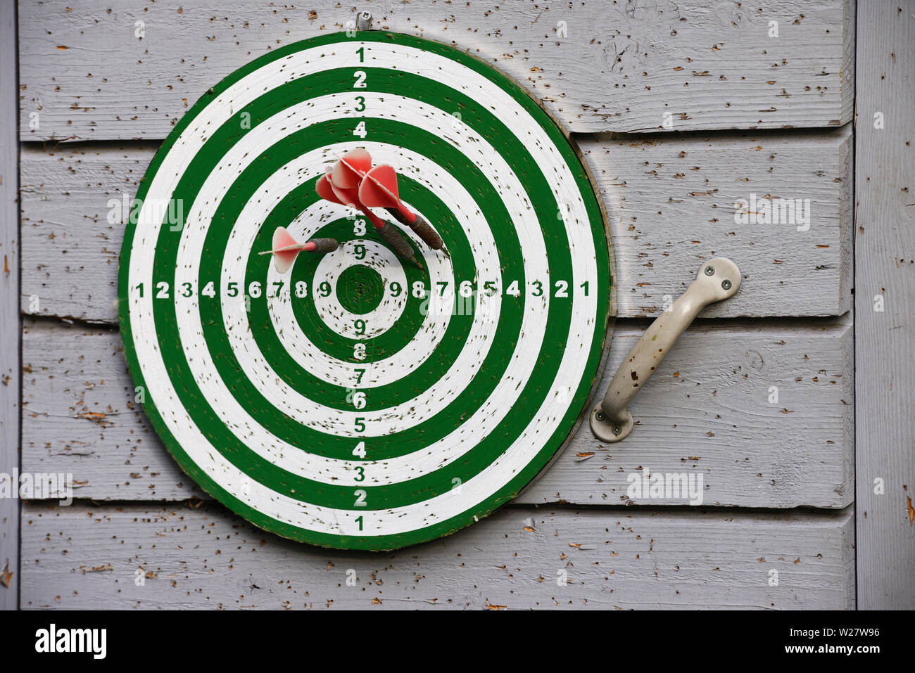 old darts target hanging on the door outside Stock Photo - Alamy