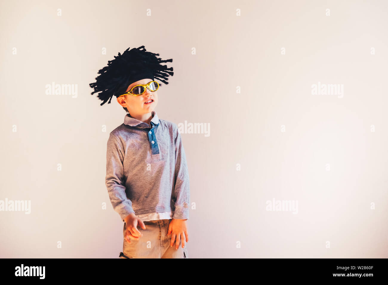 Child with rastafari wig dancing cheerful, isolated copy space white ...