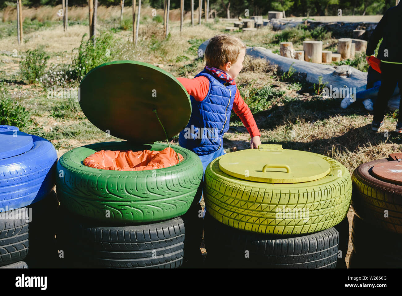 Children playing around recycling bins made with reused material Stock ...