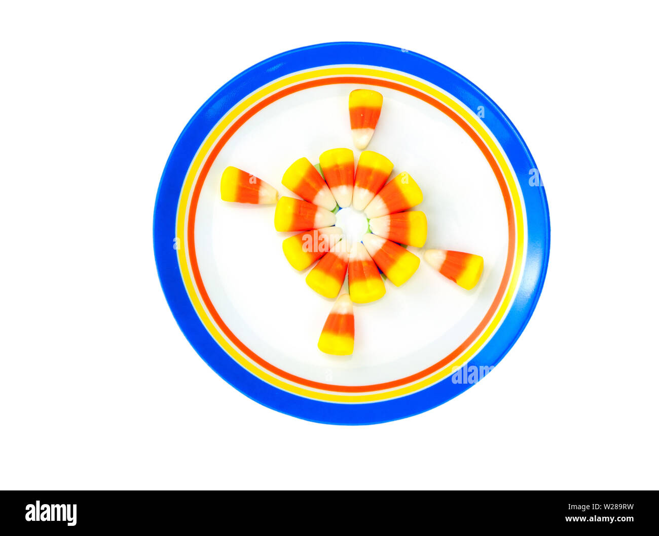 Pieces of Halloween candy corn arranged in a circle on a color ...