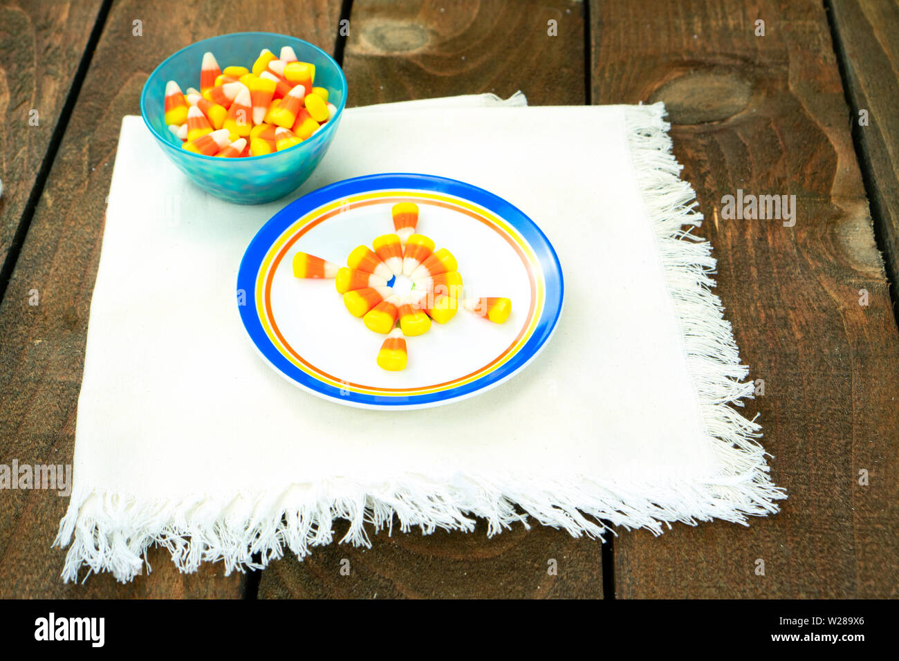 Pieces of Halloween candy corn arranged in a circle on a color ...