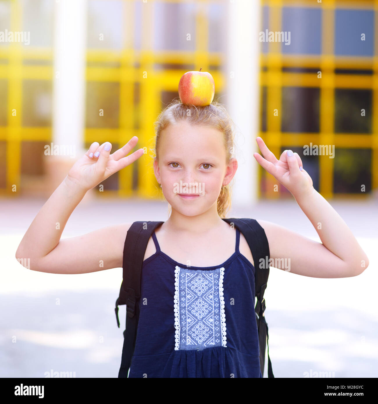 Happy Girl with apple on her head show victory sign. Great Portrait Of ...