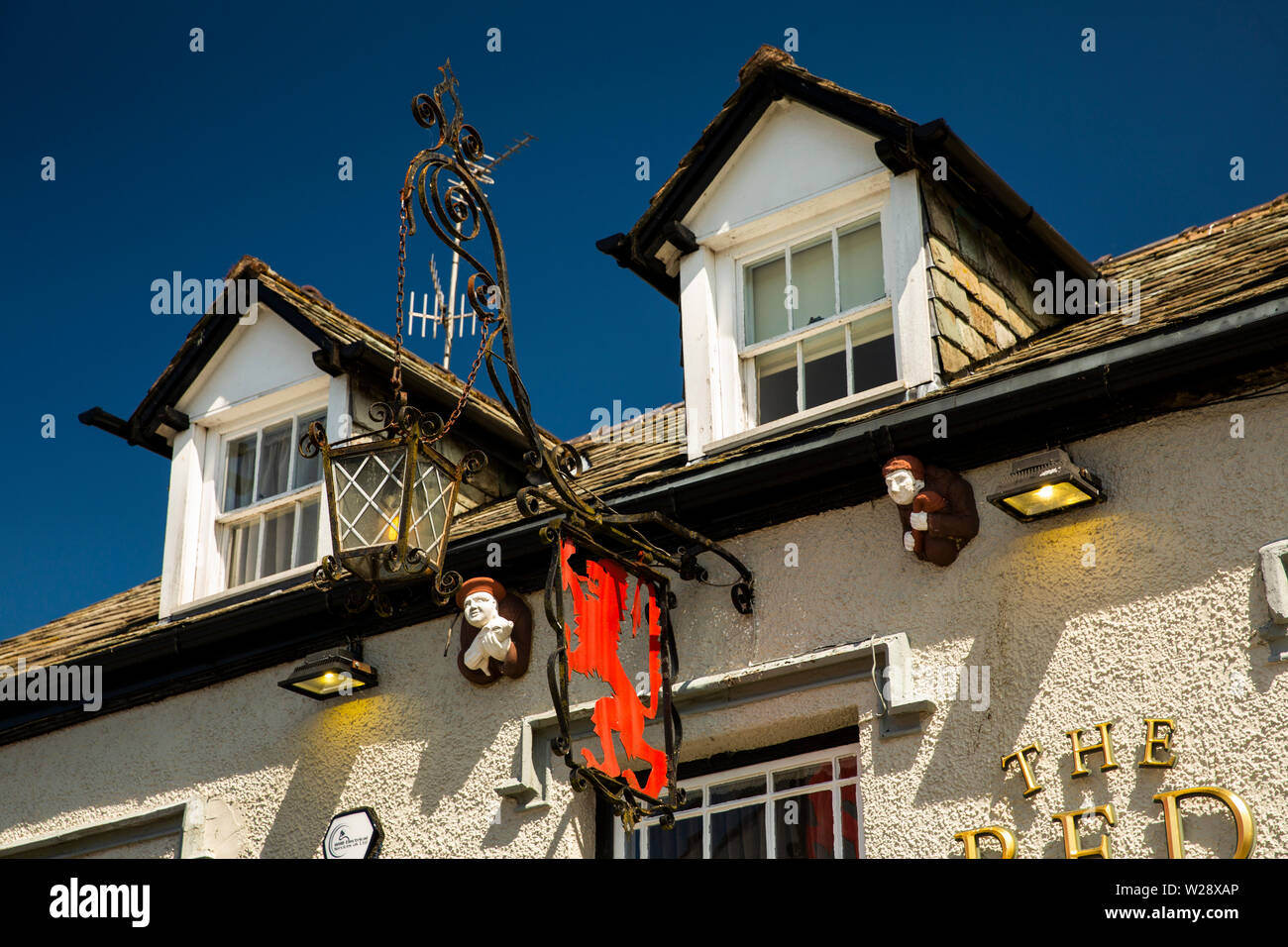 UK, Cumbria, Hawkshead, Main Street, Red Lion Pub sign with man holding ...