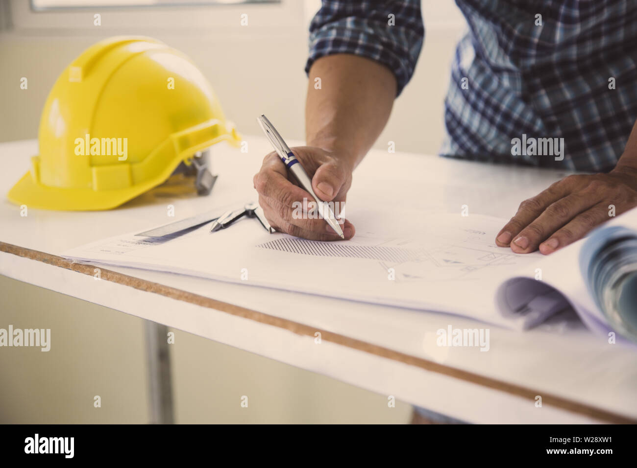 architect man handwriting with blueprint to build houses. After ...