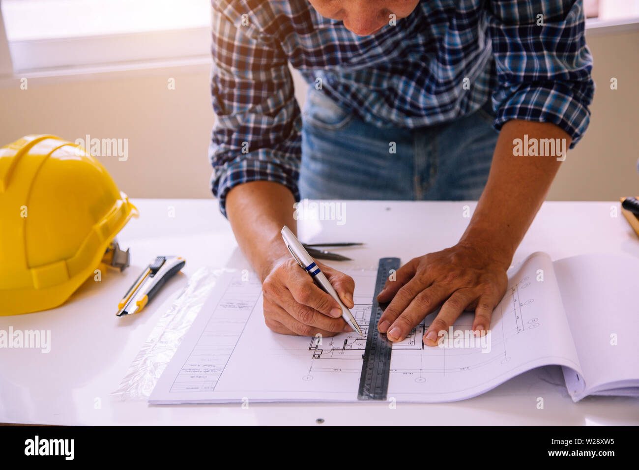 architect man handwriting with blueprint to build houses. After ...
