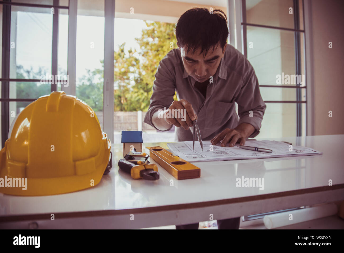 Engineer man drawings blueprint at Construction Site.Home Project to ...