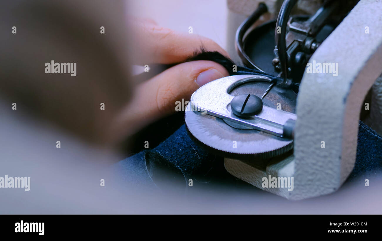 Skinner using sewing machine for stitching fur skin at atelier Stock ...