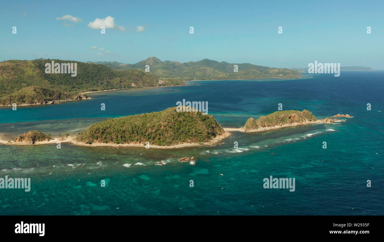 aerial view tropical island in blue lagoon, coral reef and big wave ...