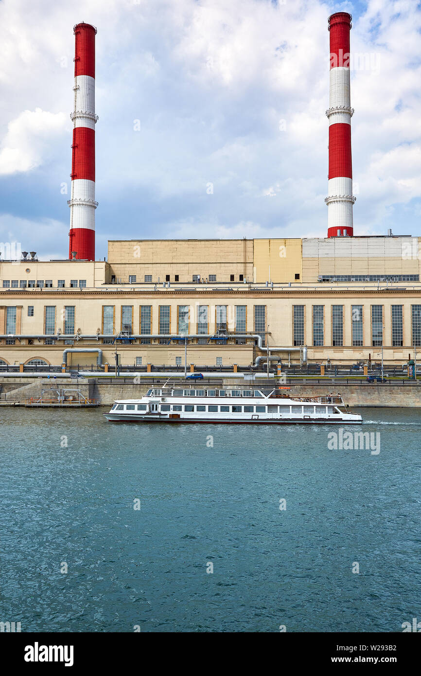 Modern riverboat on the river in the city, with urban industrial ...