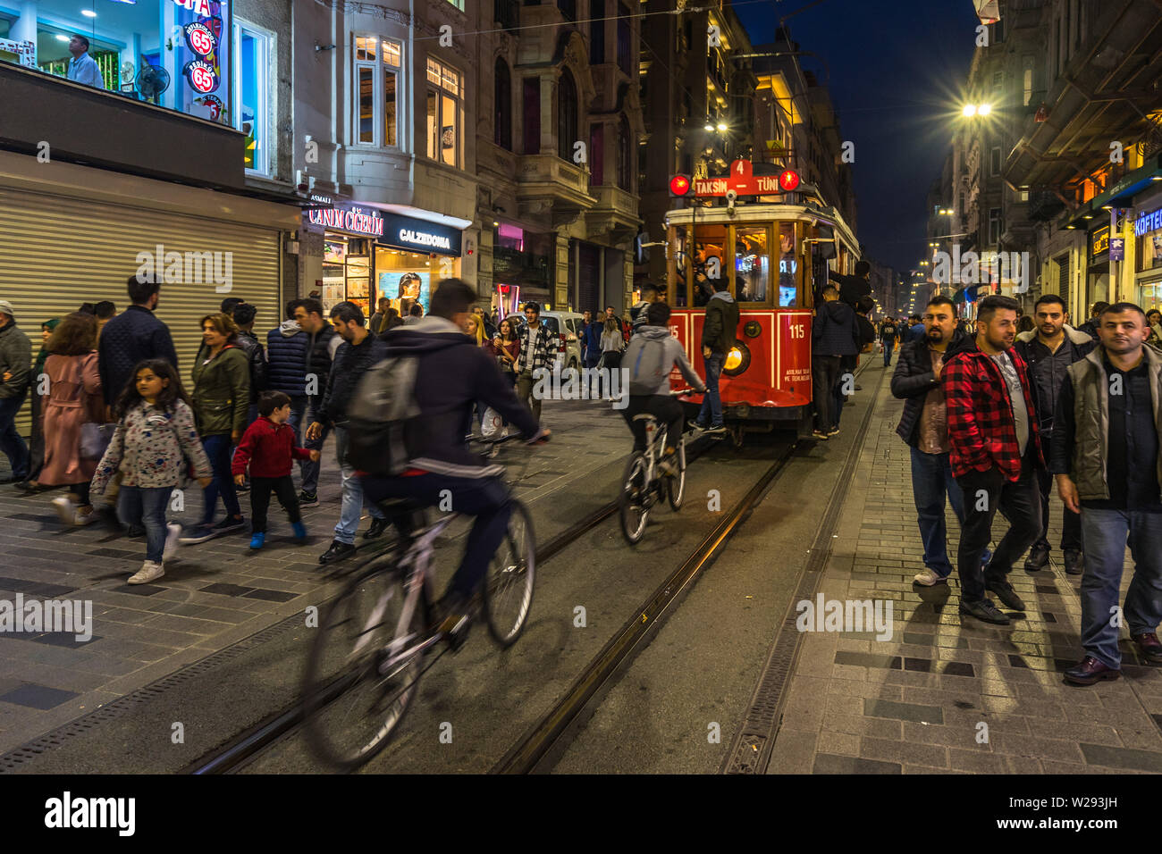 Cyclists following the Istanbul red tram in Istiklal Avenue, the most ...
