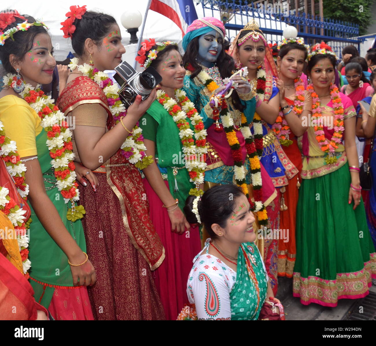 Women dancers in elaborate costumes wait to join a colourful parade by ...