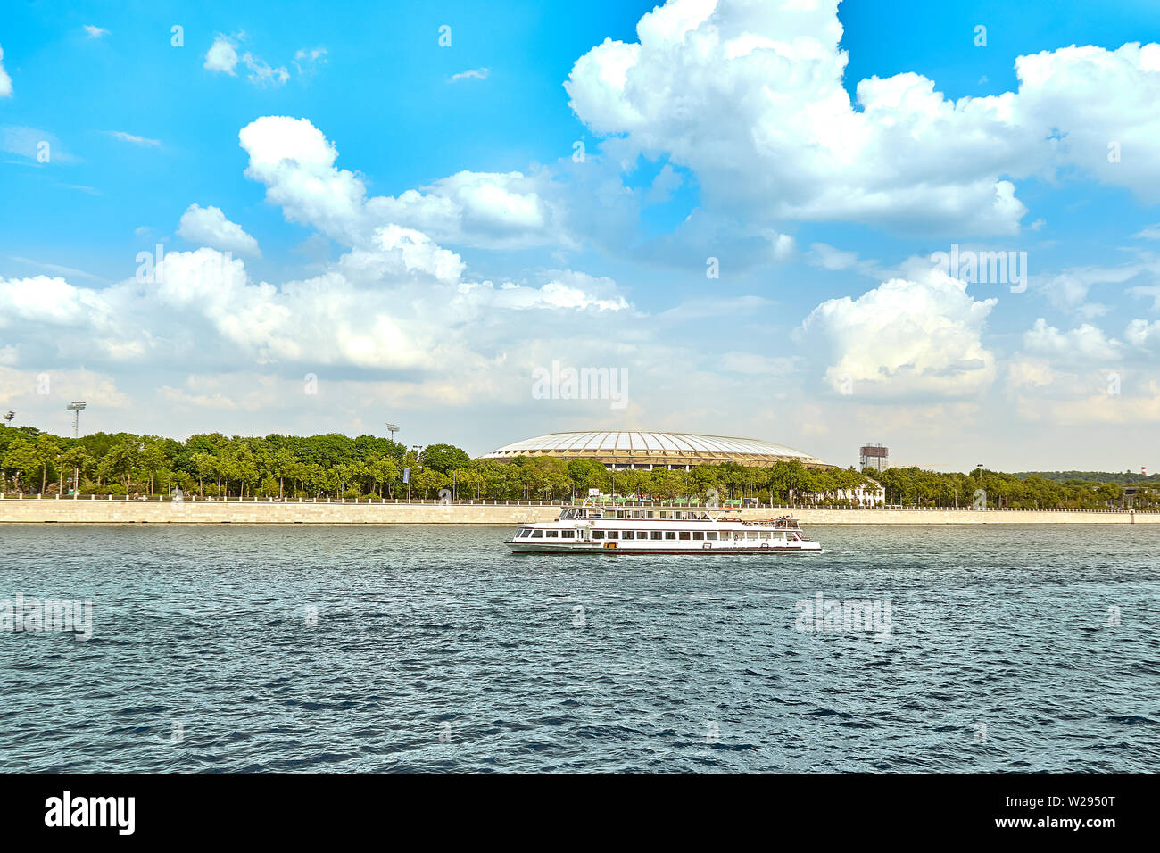 A modern riverboat floats against the backdrop of the city panorama ...