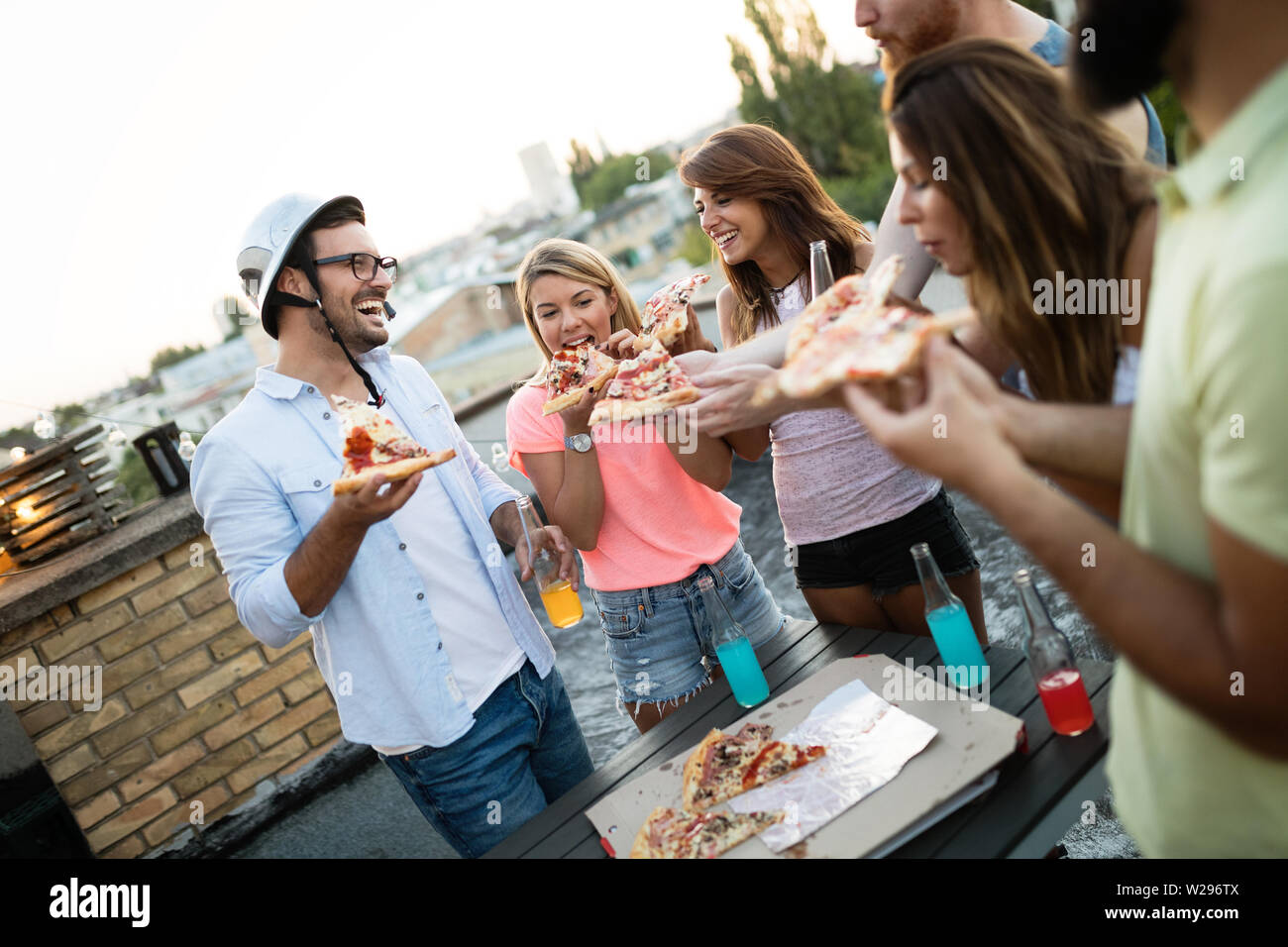 Friends and pizza. Young cheerful people eating pizza and having fun ...