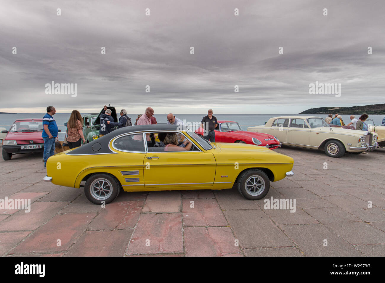 Yellow ford Capri arriving at vintage car rally on the sea front at ...