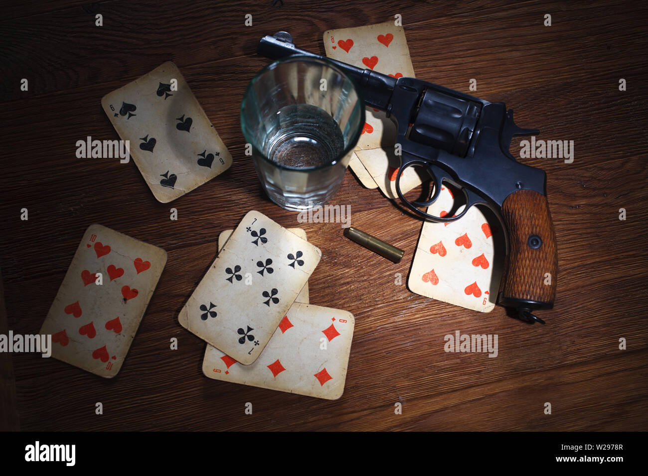 russian roulette - plaing card, glass of vodka and revolver with one ...