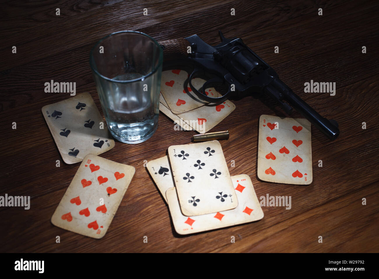 russian roulette - plaing card, glass of vodka and revolver with one ...