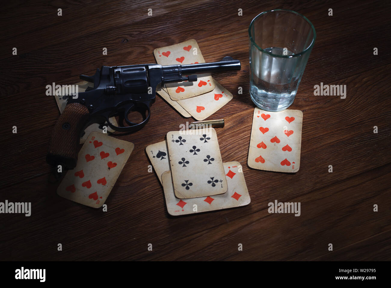 russian roulette - plaing card, glass of vodka and revolver with one ...