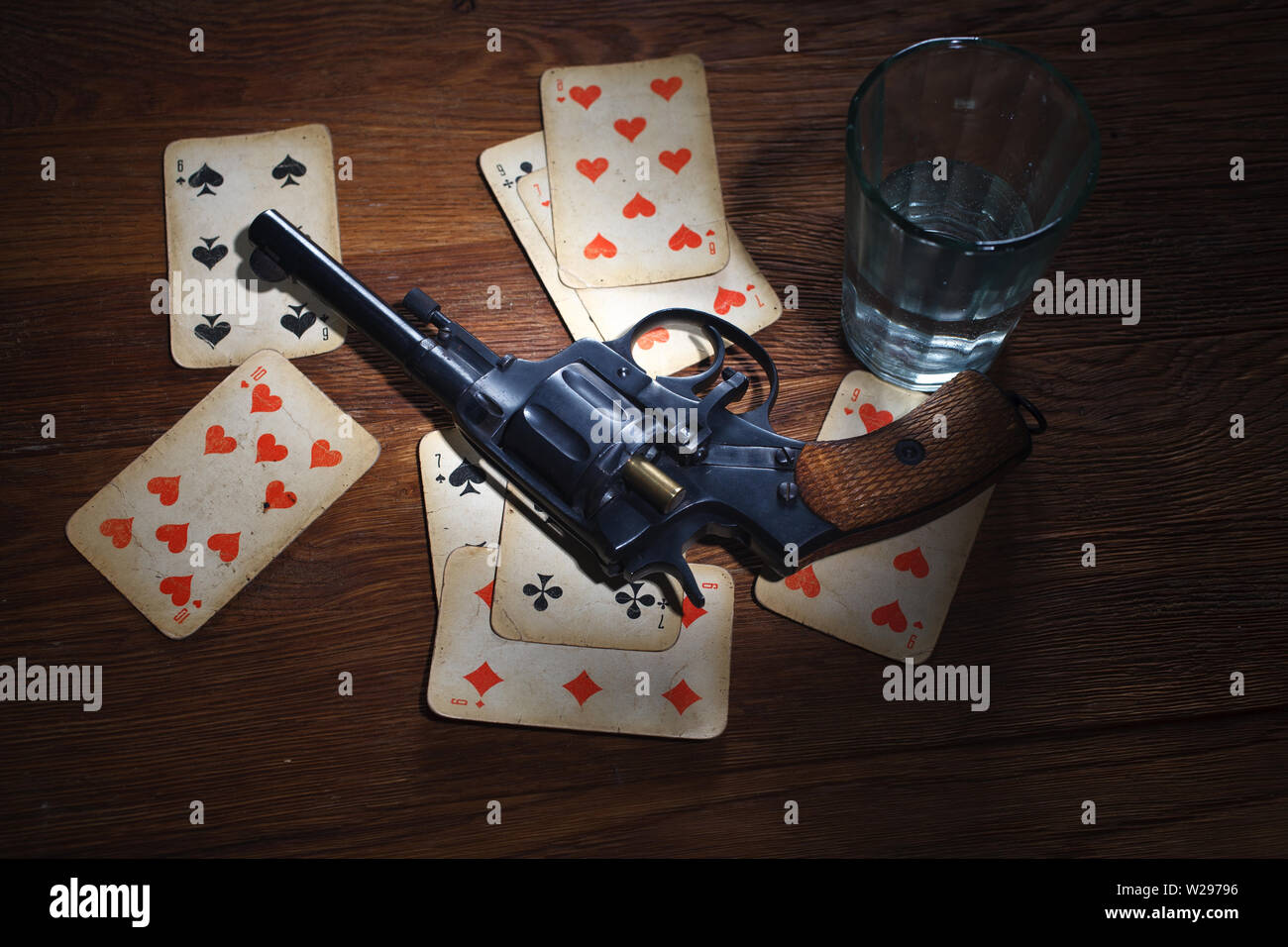 russian roulette - plaing card, glass of vodka and revolver with one ...