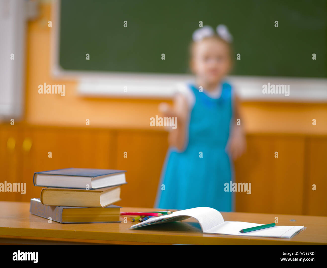 School notebook, pencils and textbooks are on the desk in the classroom ...