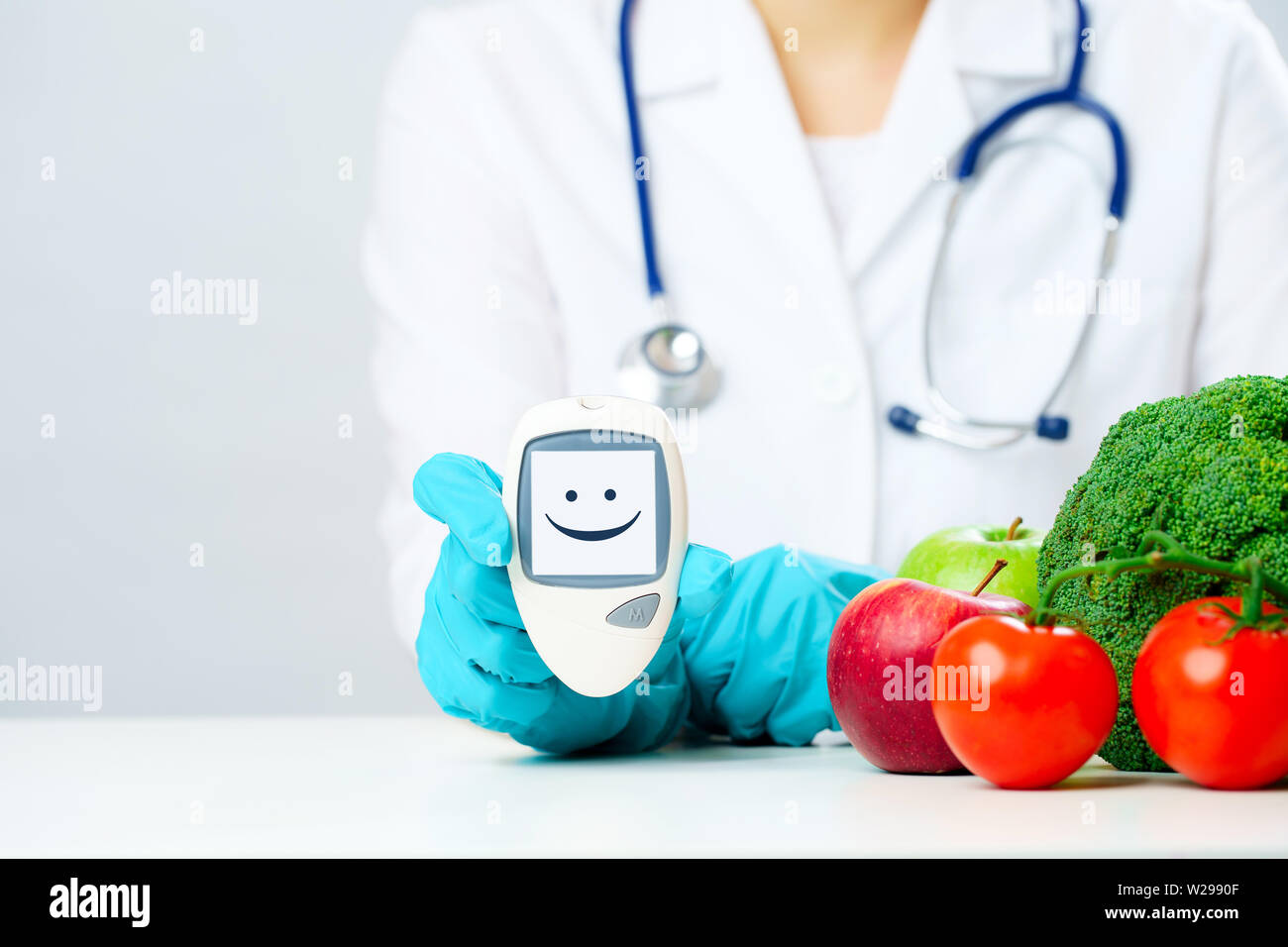 Photo of doctor in lab coat and rubber gloves with glucometer showing ...