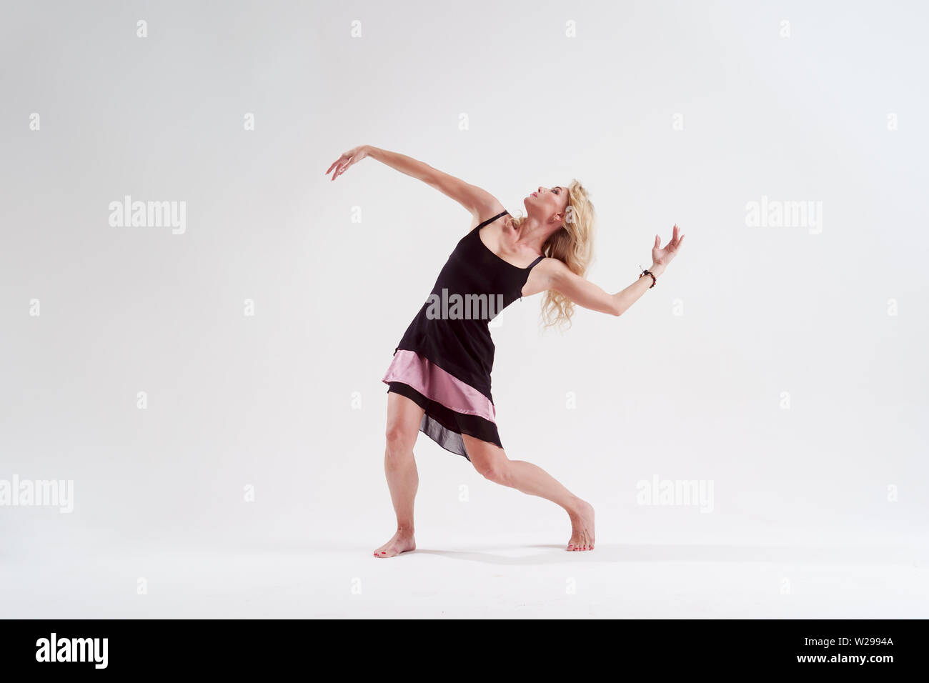 Beautiful blonde looking up dancing in studio Stock Photo - Alamy