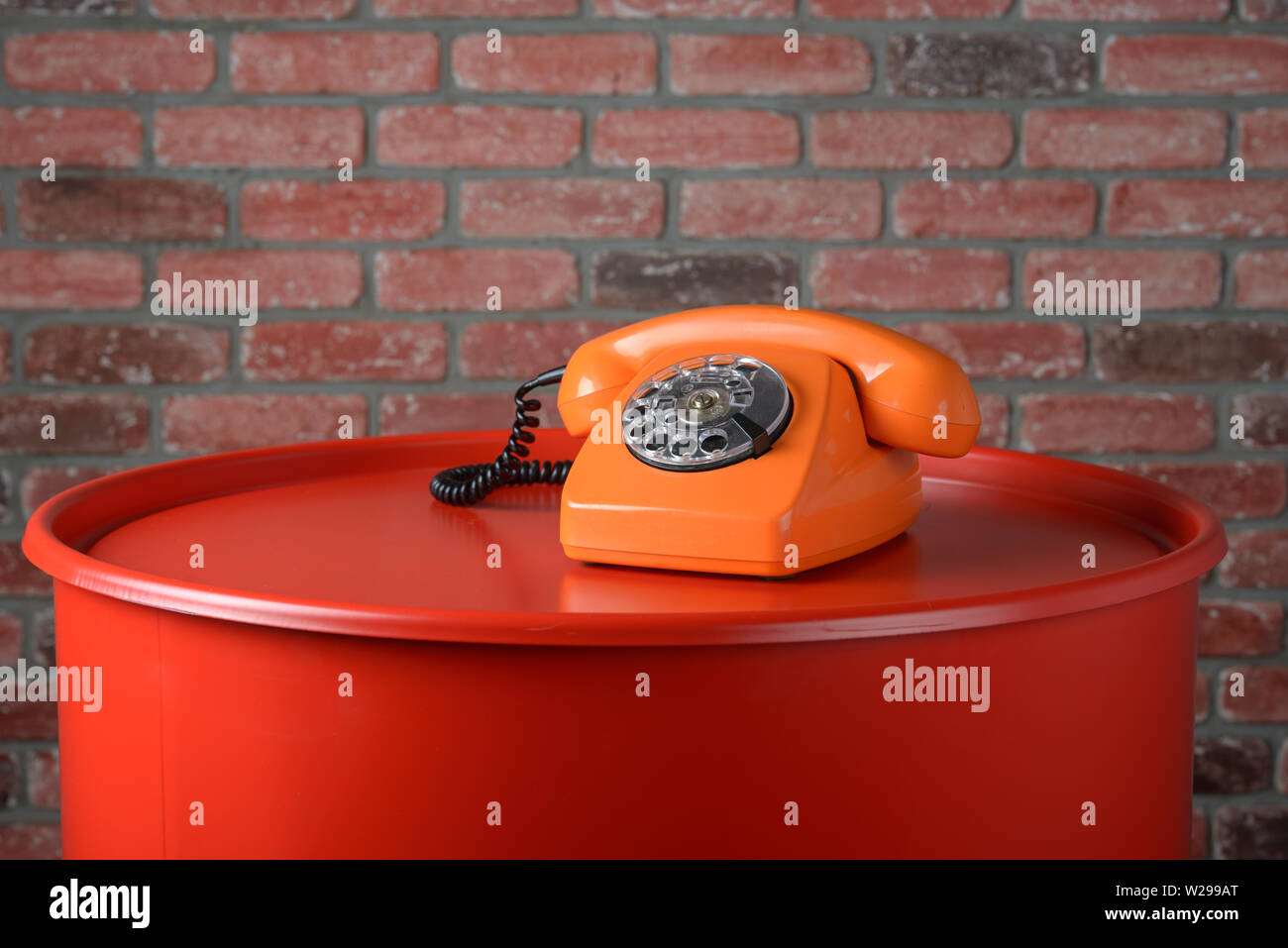 Vintage orange telephone on brick wall background Stock Photo - Alamy