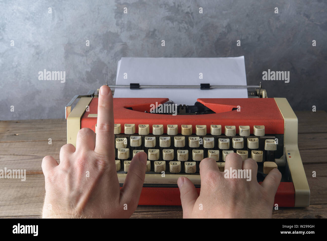 Old red typewriter on the table near the wall Stock Photo - Alamy