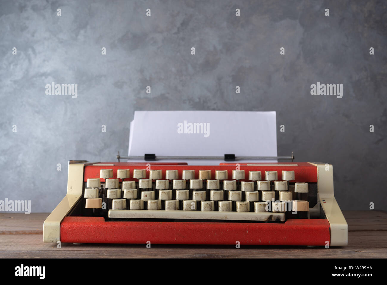Old red typewriter on the table near the wall Stock Photo - Alamy