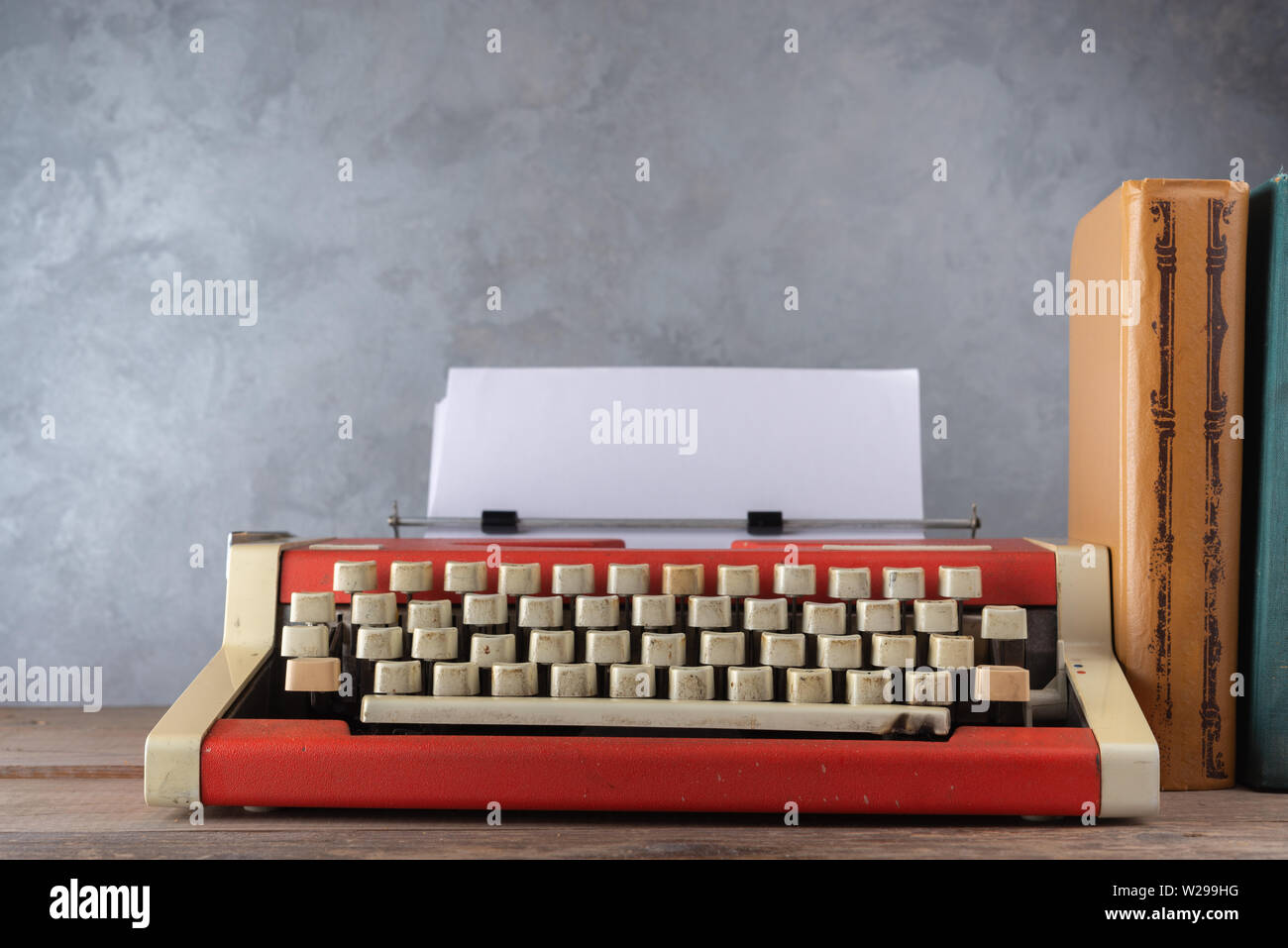 Old red typewriter on the table near the wall Stock Photo - Alamy