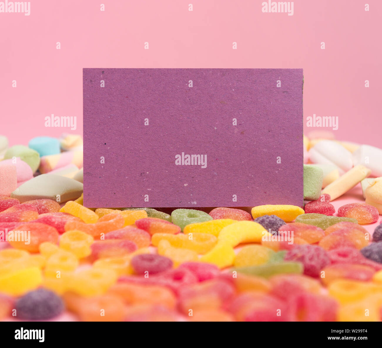 Pink paper background with sugary jellies and blank notepad. Place for ...