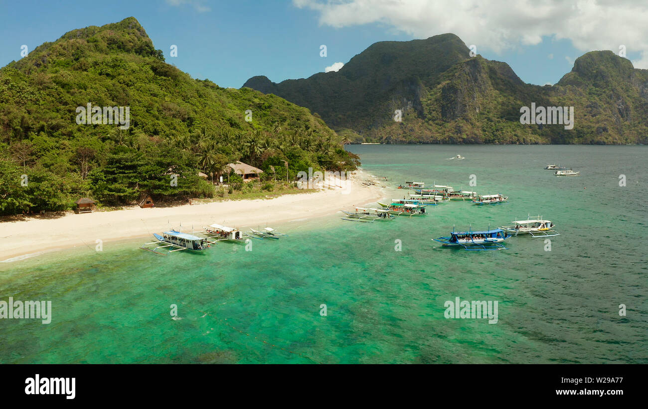 aerial view tropical beach on island with palm trees, blue lagoon and ...