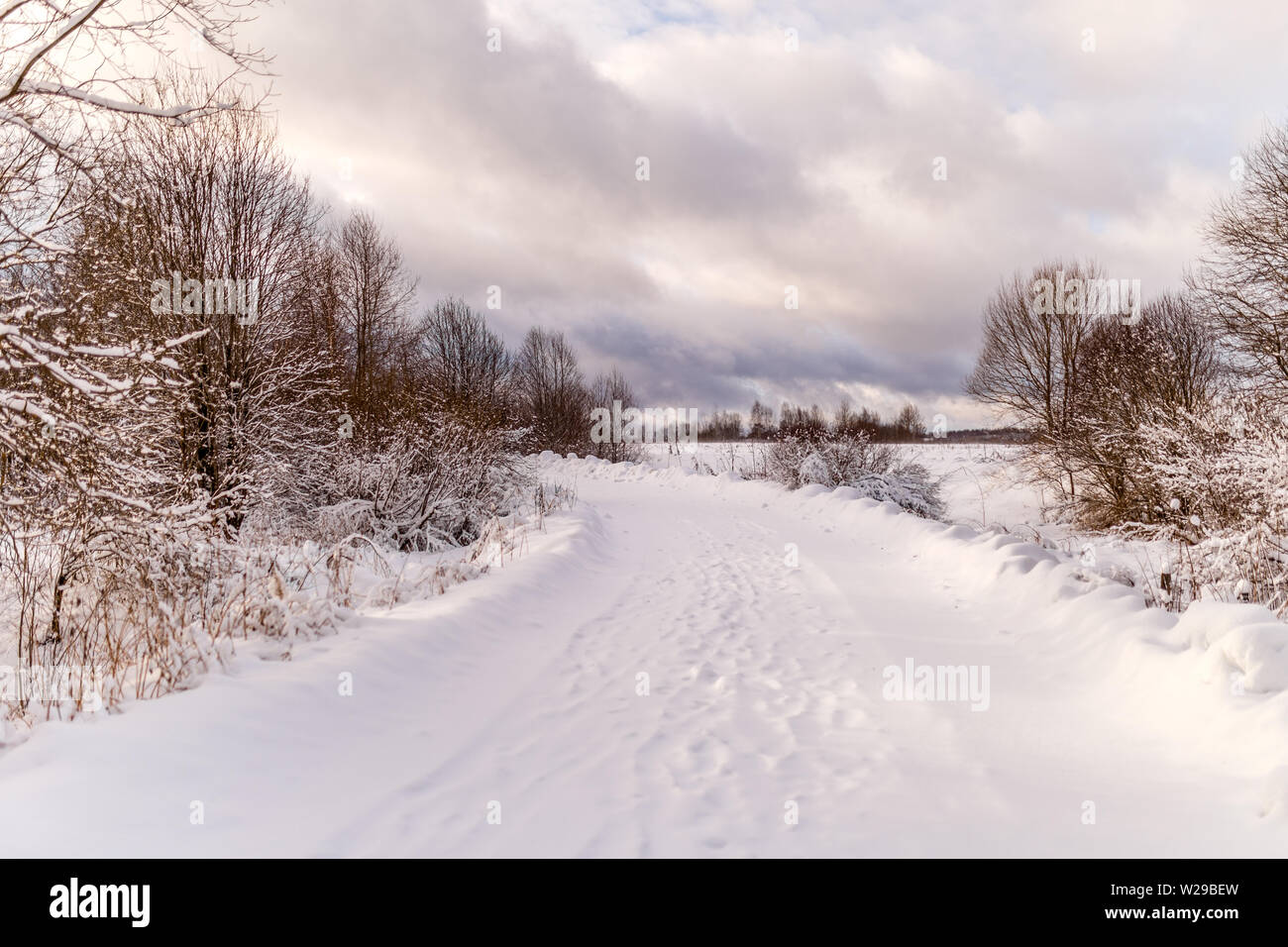 Photo of snowy landscape with cloudy sky and road Stock Photo - Alamy