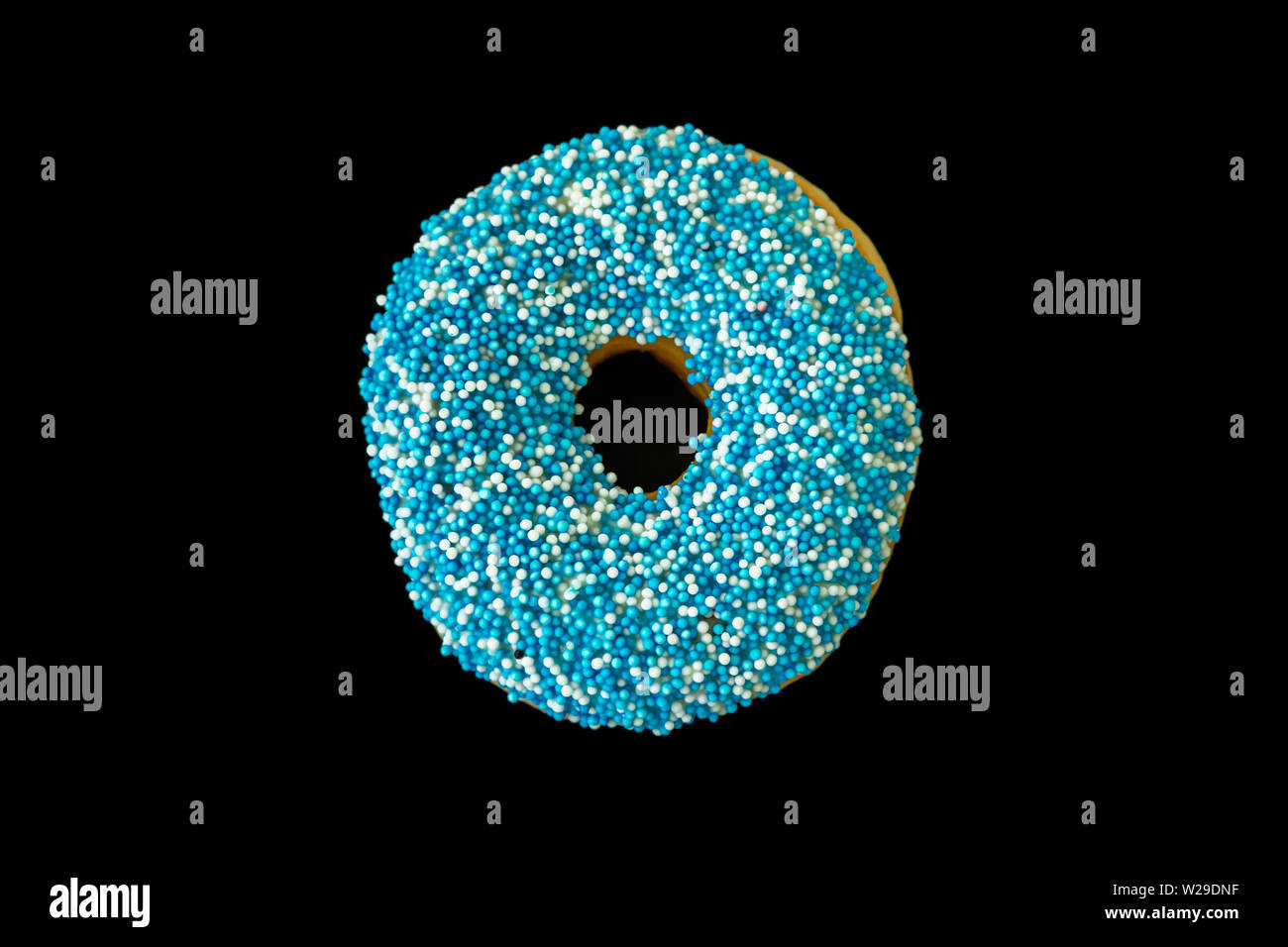 Blue donut. One donut with blue and white decoration isolated on black ...